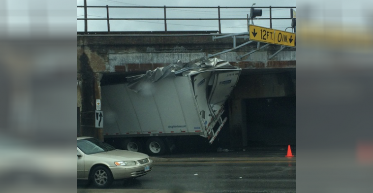 Semi trailer's roof peels off after getting stuck under railroad crossing