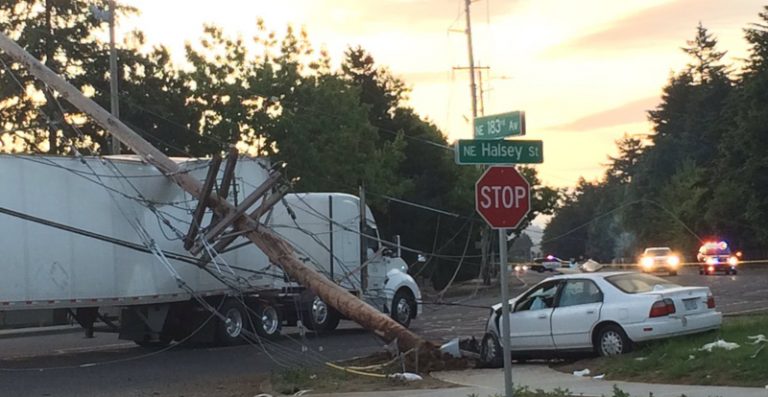 Car knocks power pole onto semi truck, trapping driver inside for hours