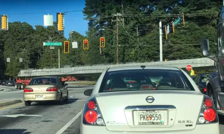 Concrete beam falls off truck at intersection, nearly flattens flagger